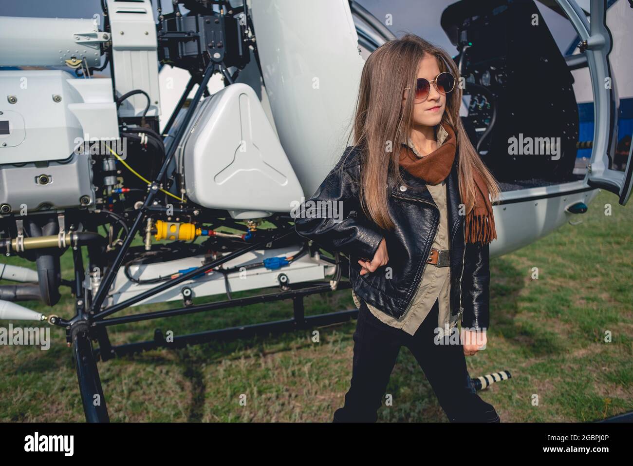 Confident tween girl in sunglasses standing near open helicopter Stock ...