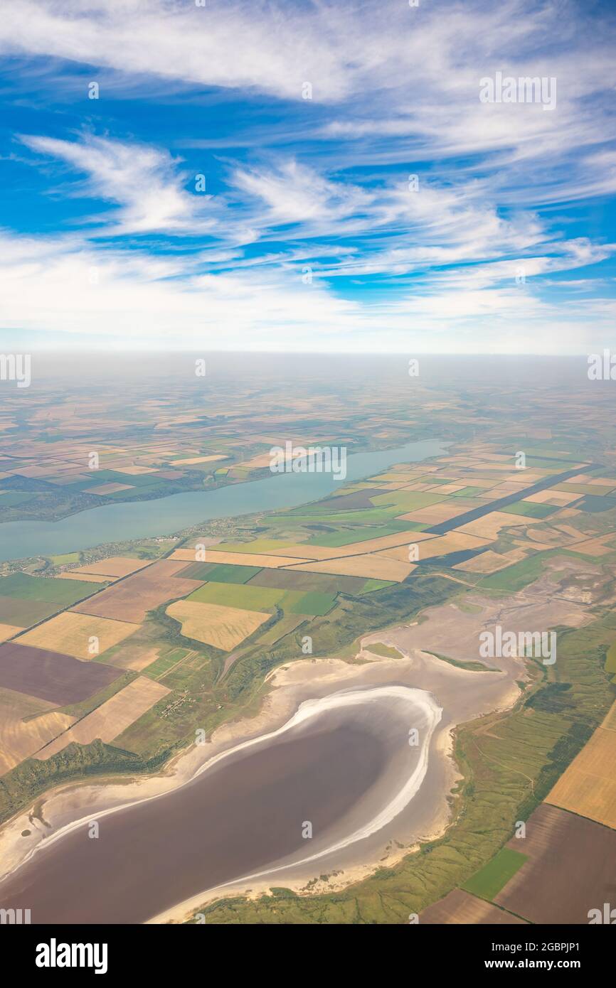 Land view through the airplane window. Fields, roads, rivers from a ...