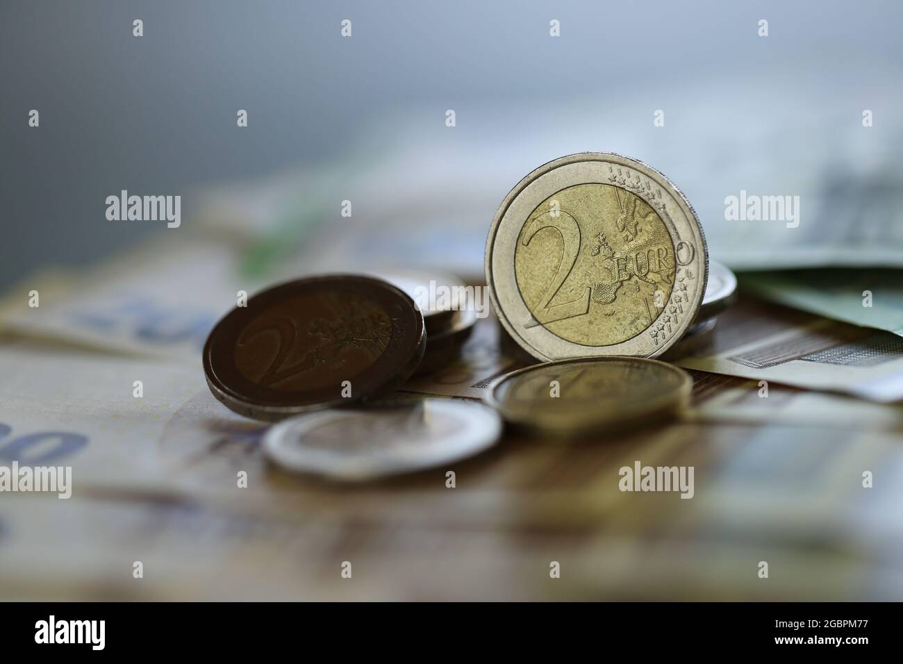 Money. Euro coins and euro banknotes on a blurred green background ...