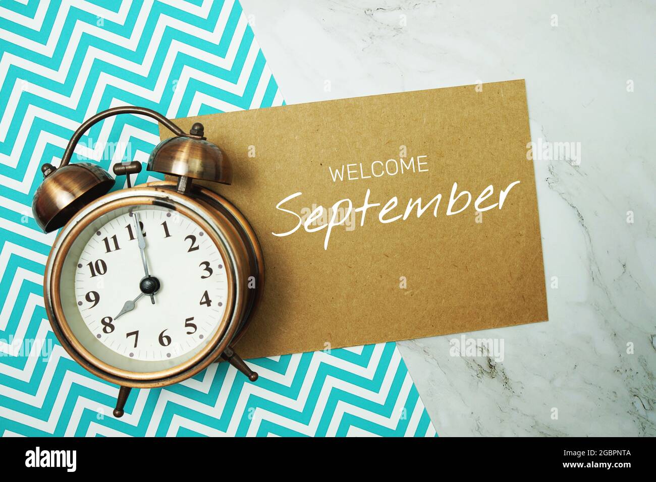 Welcome September typography text on paper card with alarm clock on ...