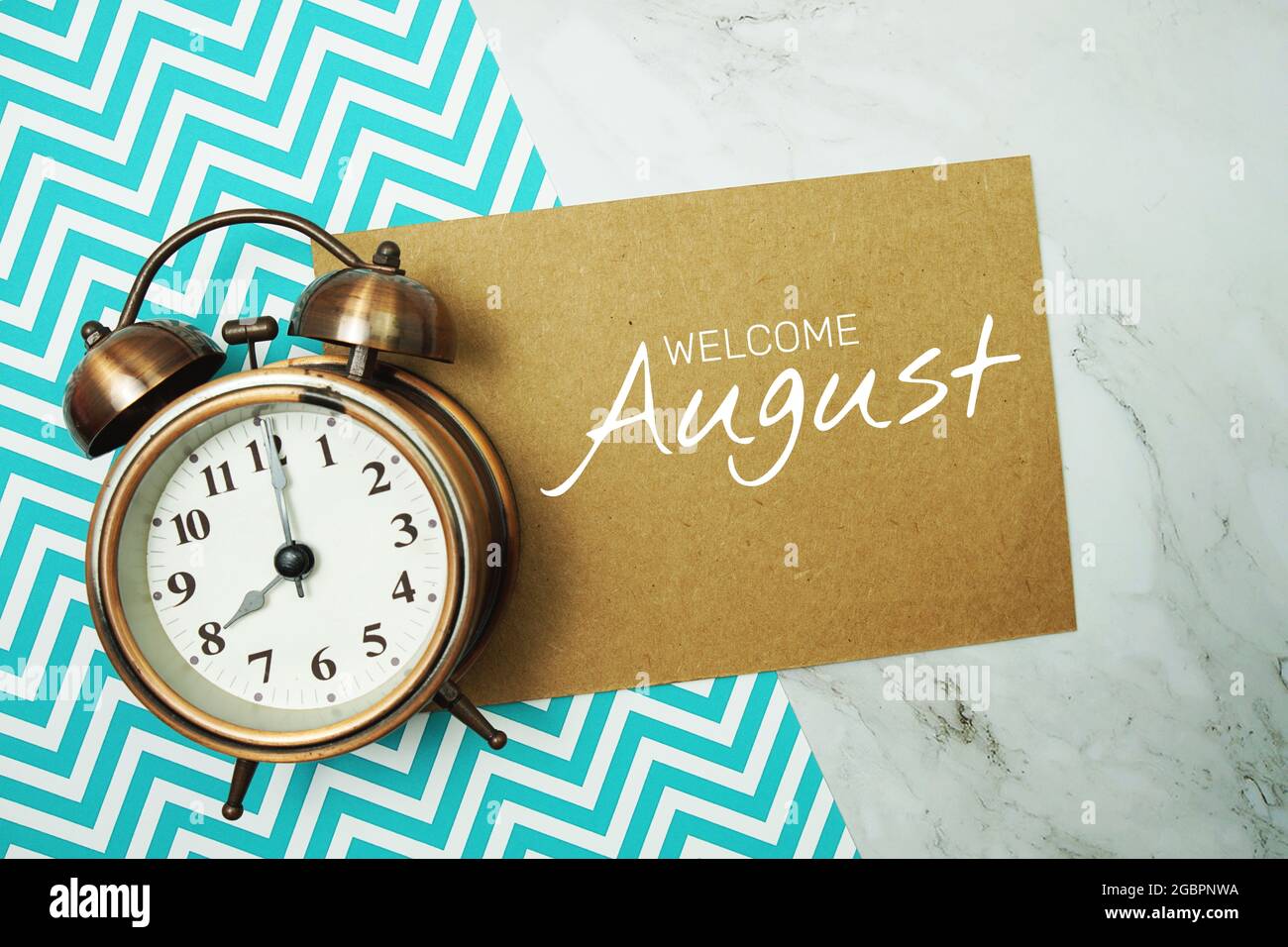 Welcome August typography text on paper card with alarm clock on marble ...