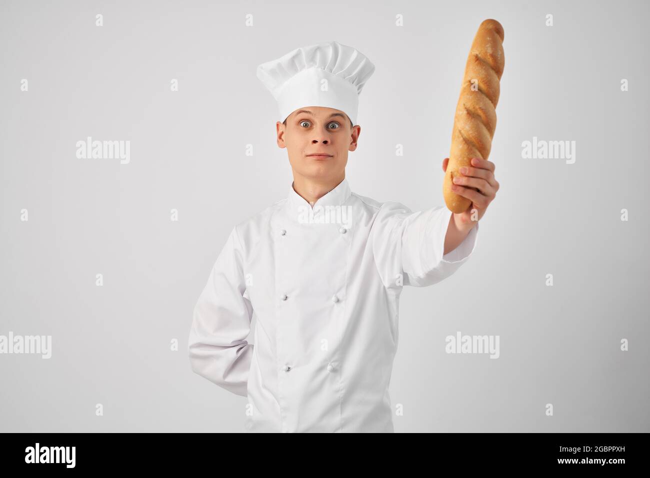 Cheerful male chef biting a loaf cooking food bakery Stock Photo - Alamy