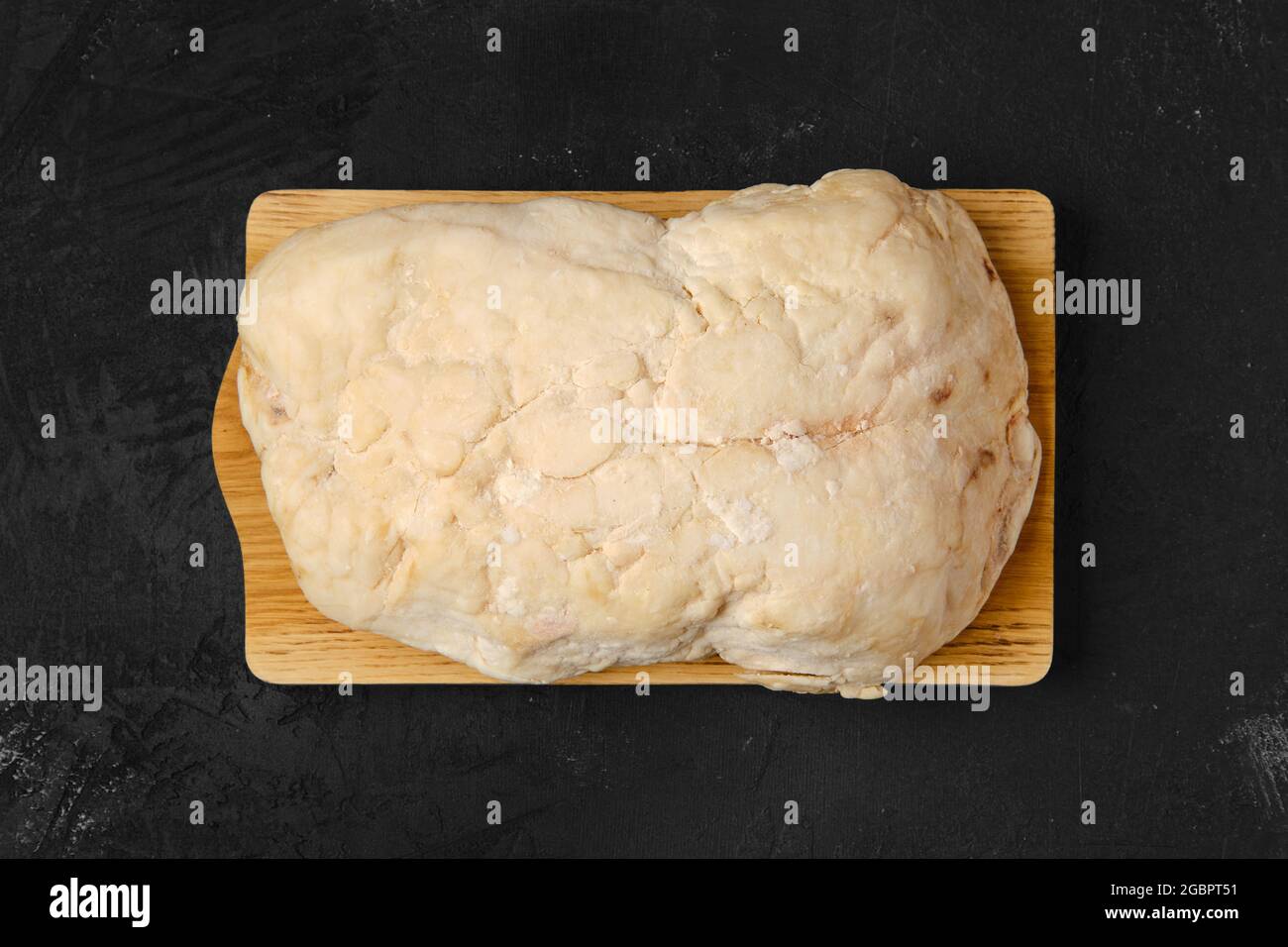 Overhead view of lamb fat tail on kitchen table with salt and pepper ...