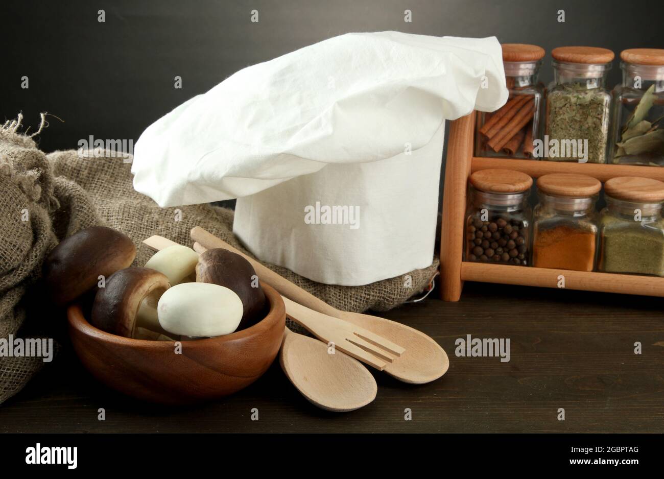 Composition with chef's hat and kitchenwear on table on grey background ...