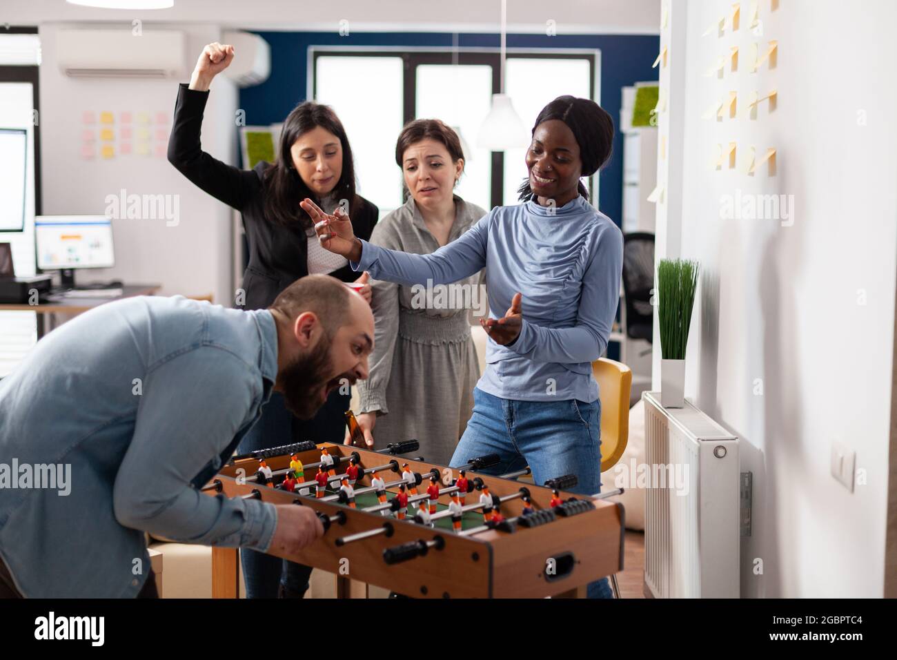 Diverse team of friends enjoying competition after work playing at ...