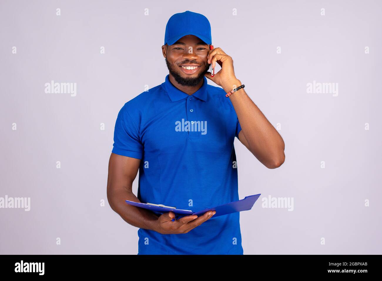 african delivery worker, smiling while making a phone call Stock Photo ...