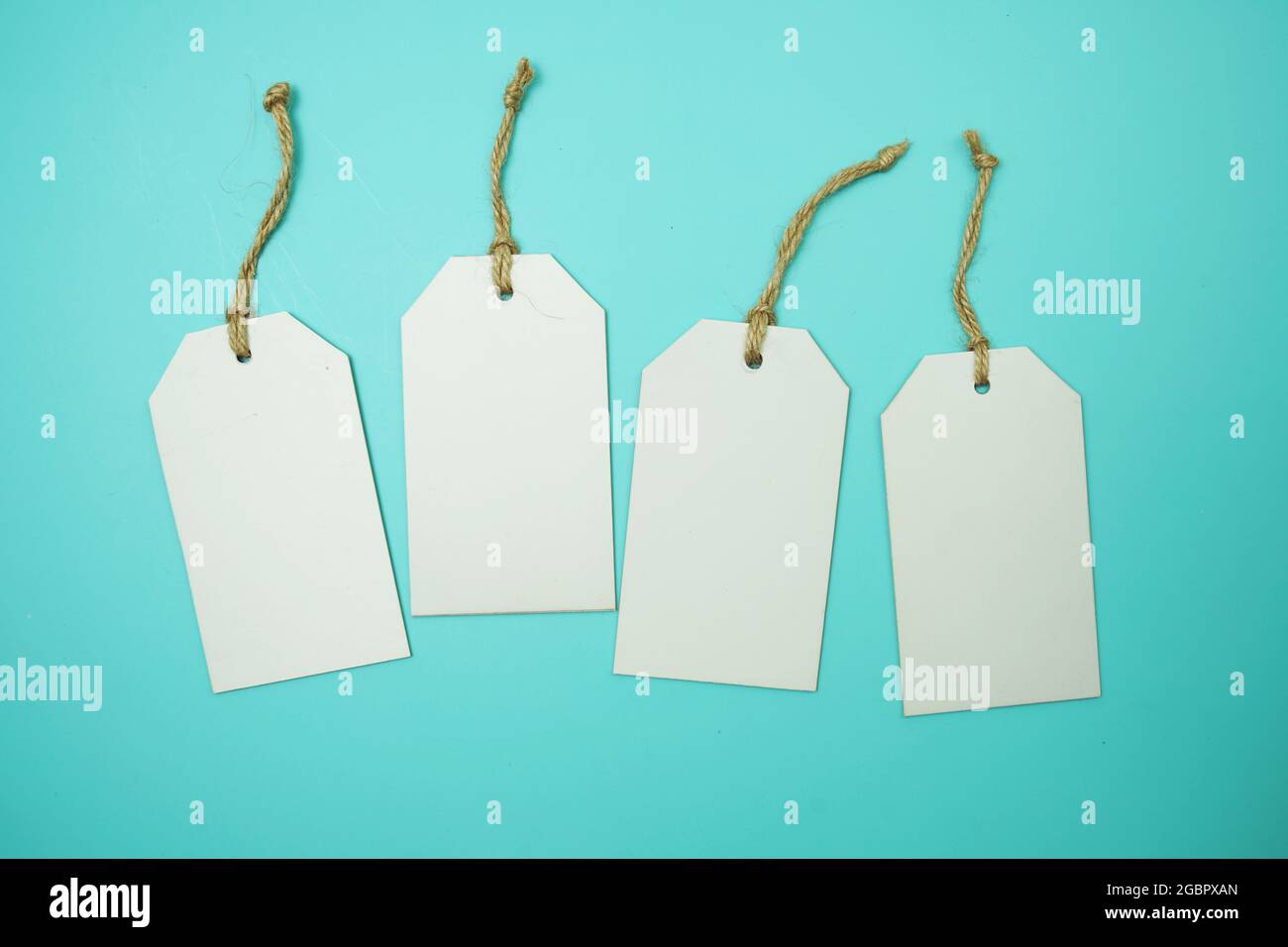 Flat lay White Blank Tag on blue background Stock Photo - Alamy