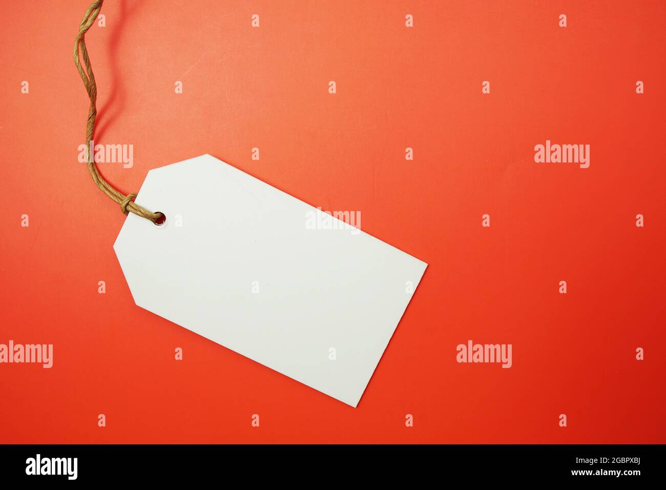 Flat lay White Blank Tag on red background Stock Photo - Alamy