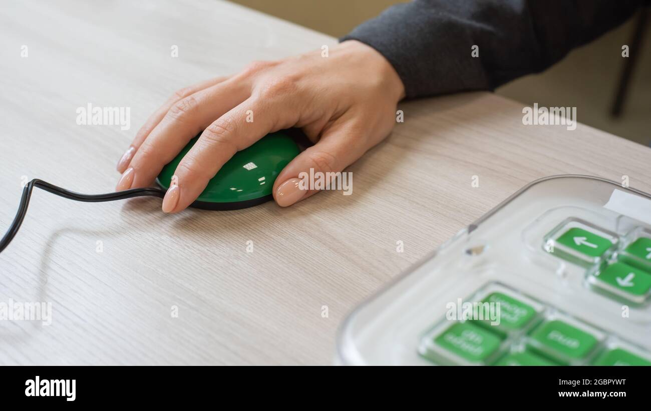 A woman with cerebral palsy uses a specialized orgonomic computer mouse ...