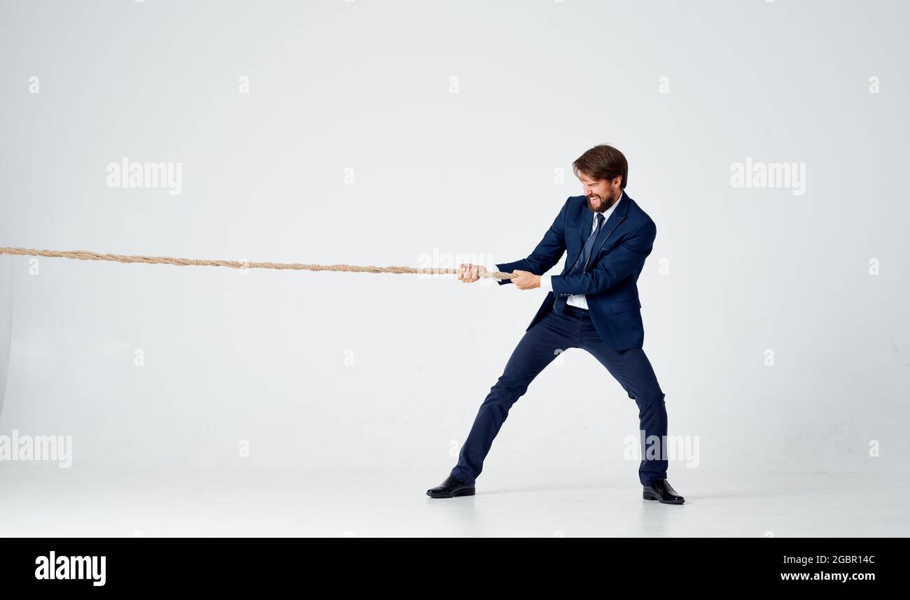 business man in a suit pulls the rope studio light background Stock ...