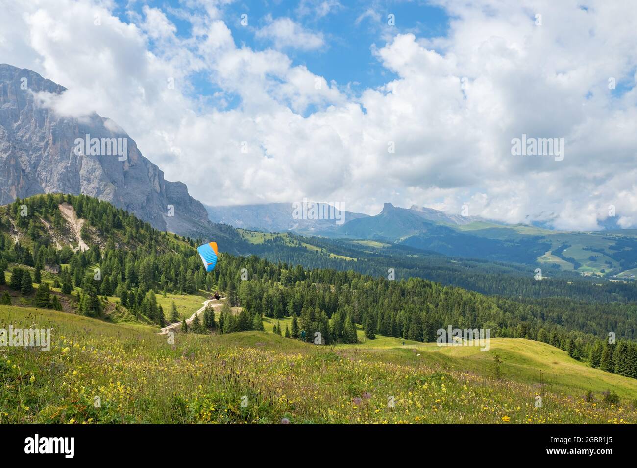 Awesome alps landscape with a flying paraglider Stock Photo - Alamy