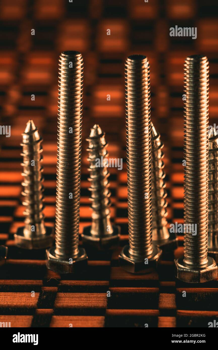Vertical closeup of golden screws and bolts on the checkerboard Stock ...