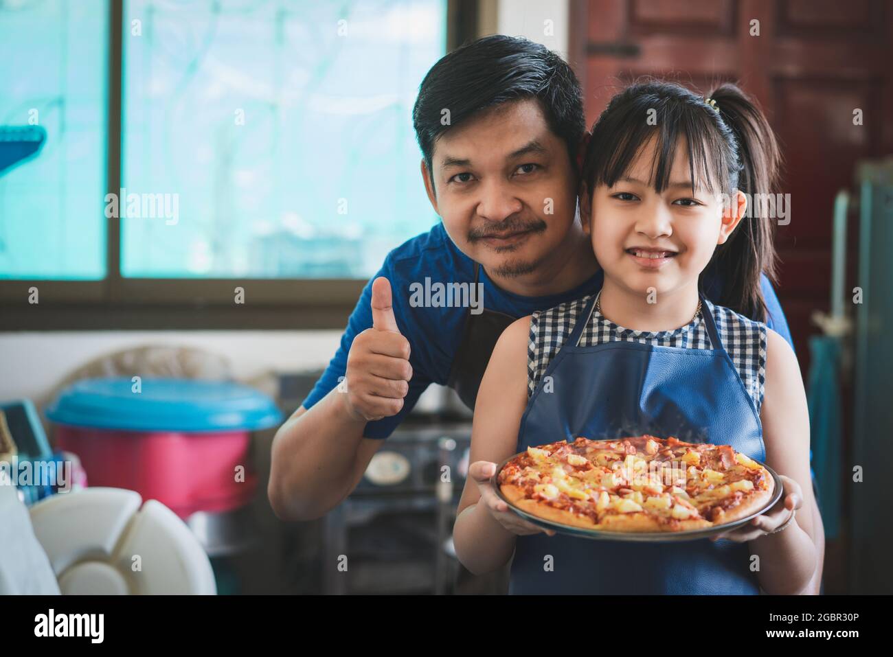 Daughter and father make pizza together happily in the kitchen. Family ...