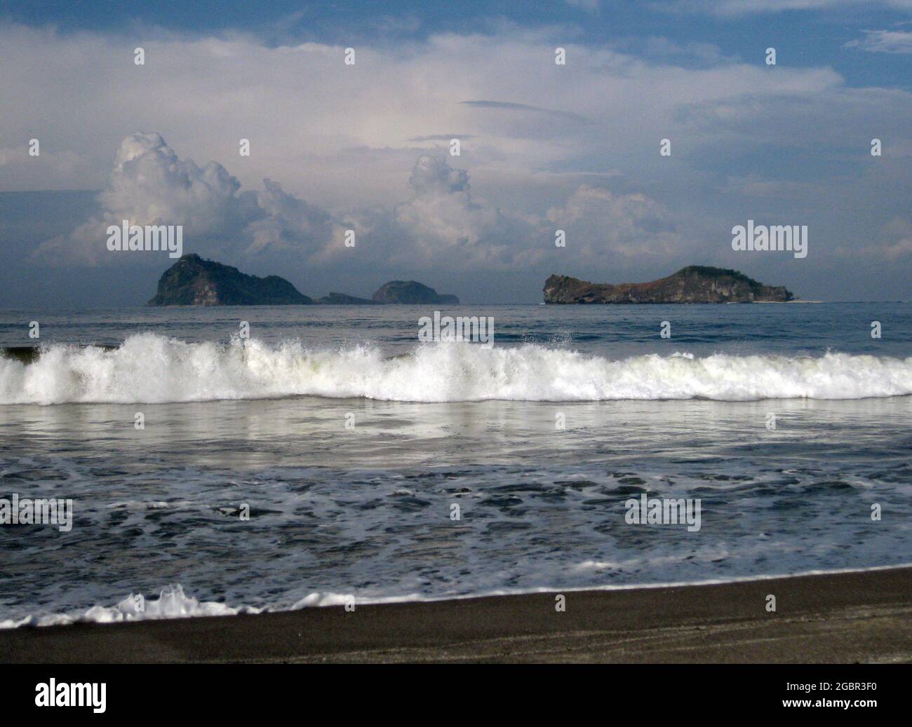 Mesmerizing view of the waves splashing on the sandy beach in summer ...