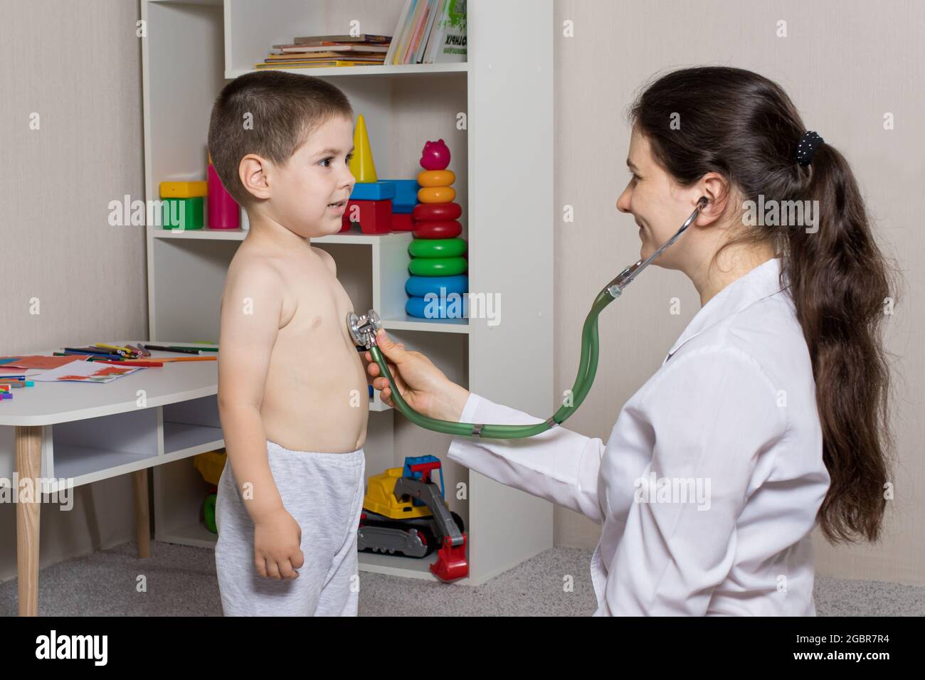The pediatrician will auscultize the lungs and heart of a little boy 3 ...