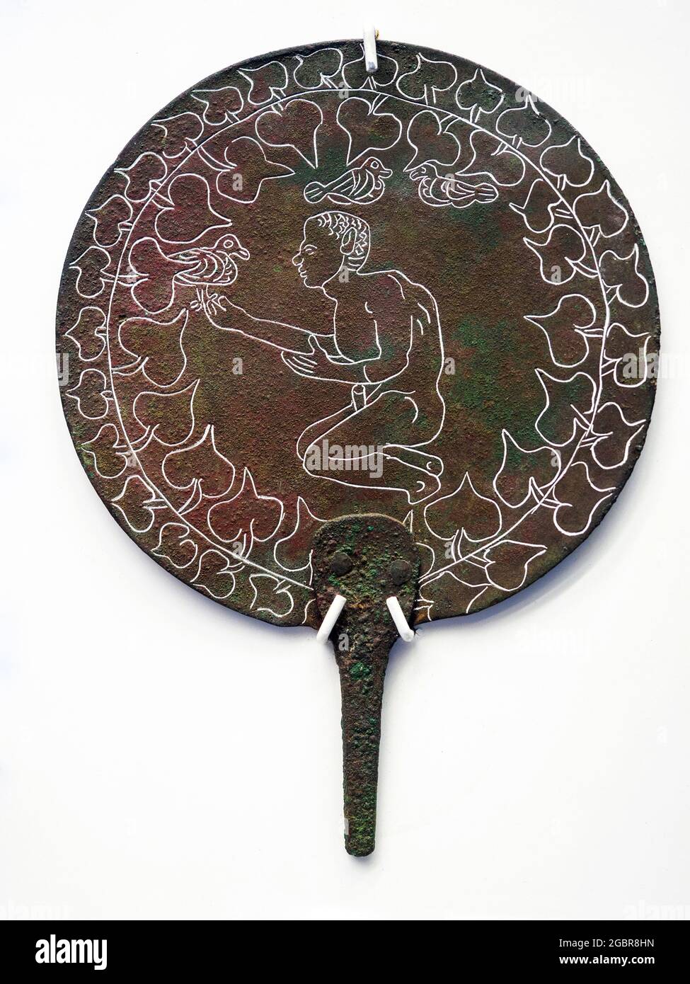 Circular tang-shaped mirror depicting a crouching satyr, hunchbacked ...