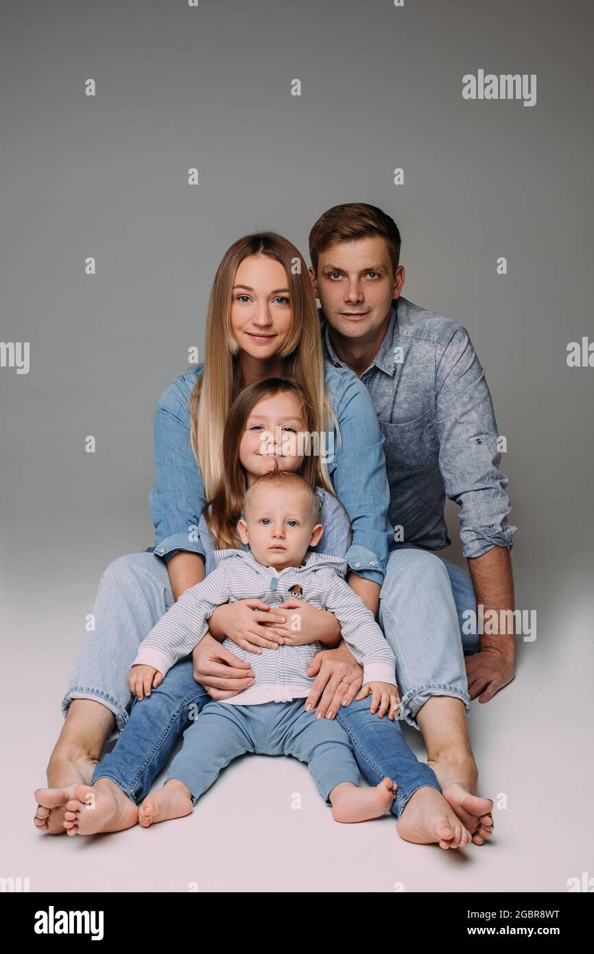 Family of four posing in denim dress code Stock Photo - Alamy