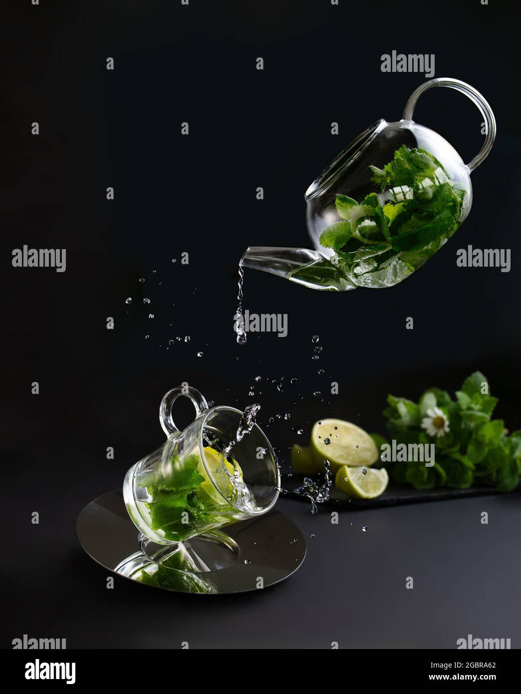 Floating glass tea pot with mint tea pouring into a transparent mug ...