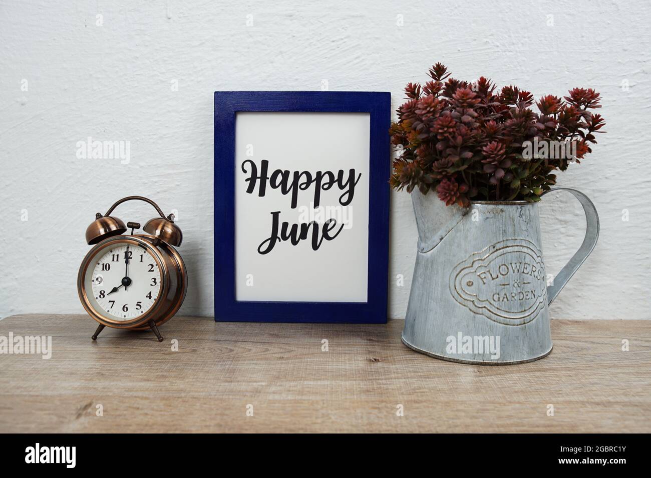 Happy June typography text with alarm clock and artificial plant ...
