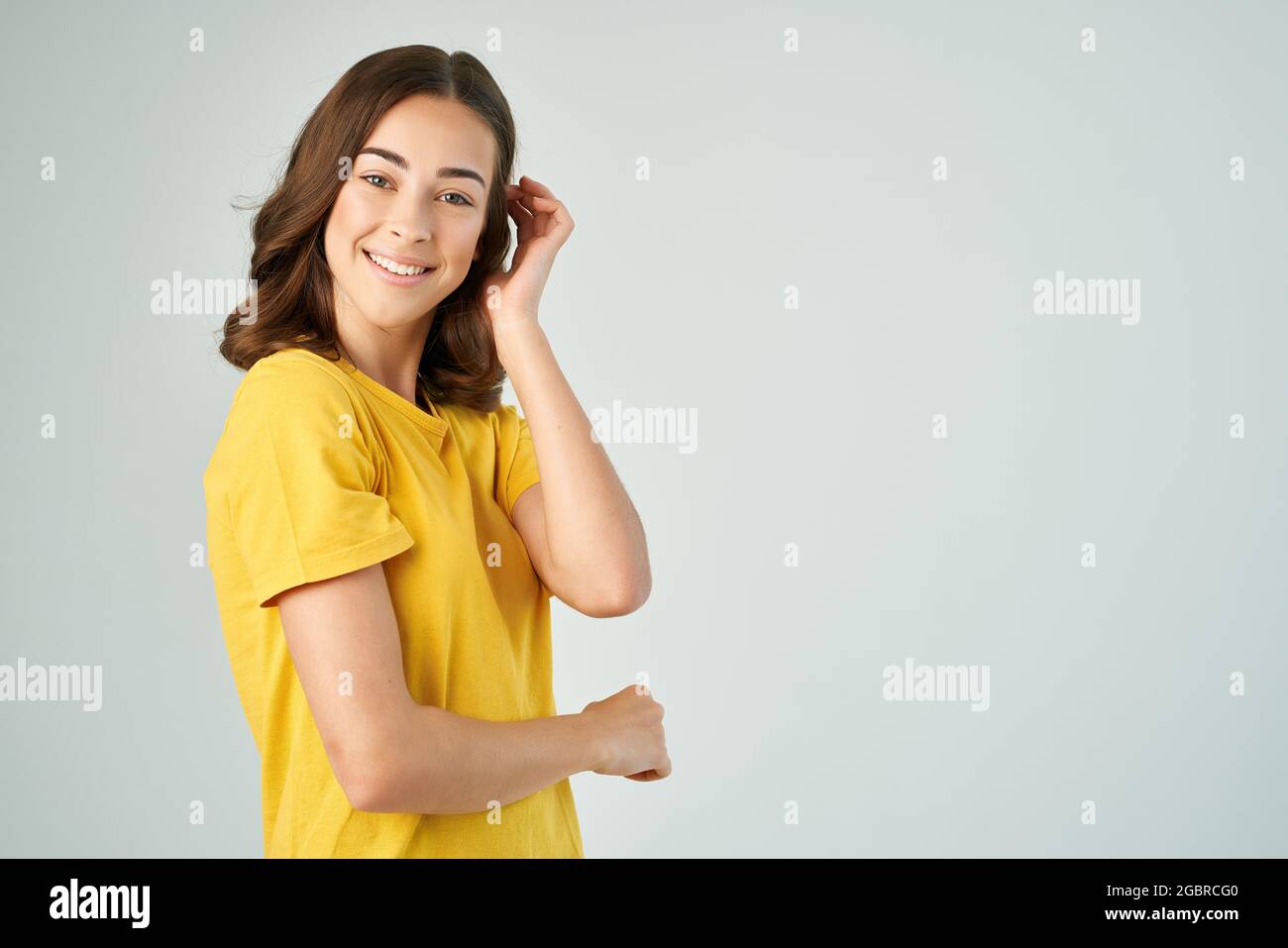 pretty brunette in a yellow t-shirt stylish hairstyle smile modern ...