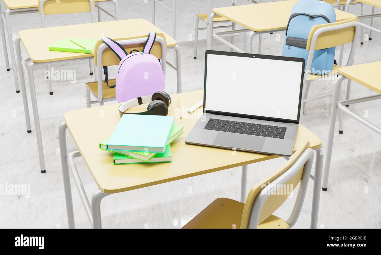 laptop with blank screen on a school desk in a classroom with books and ...