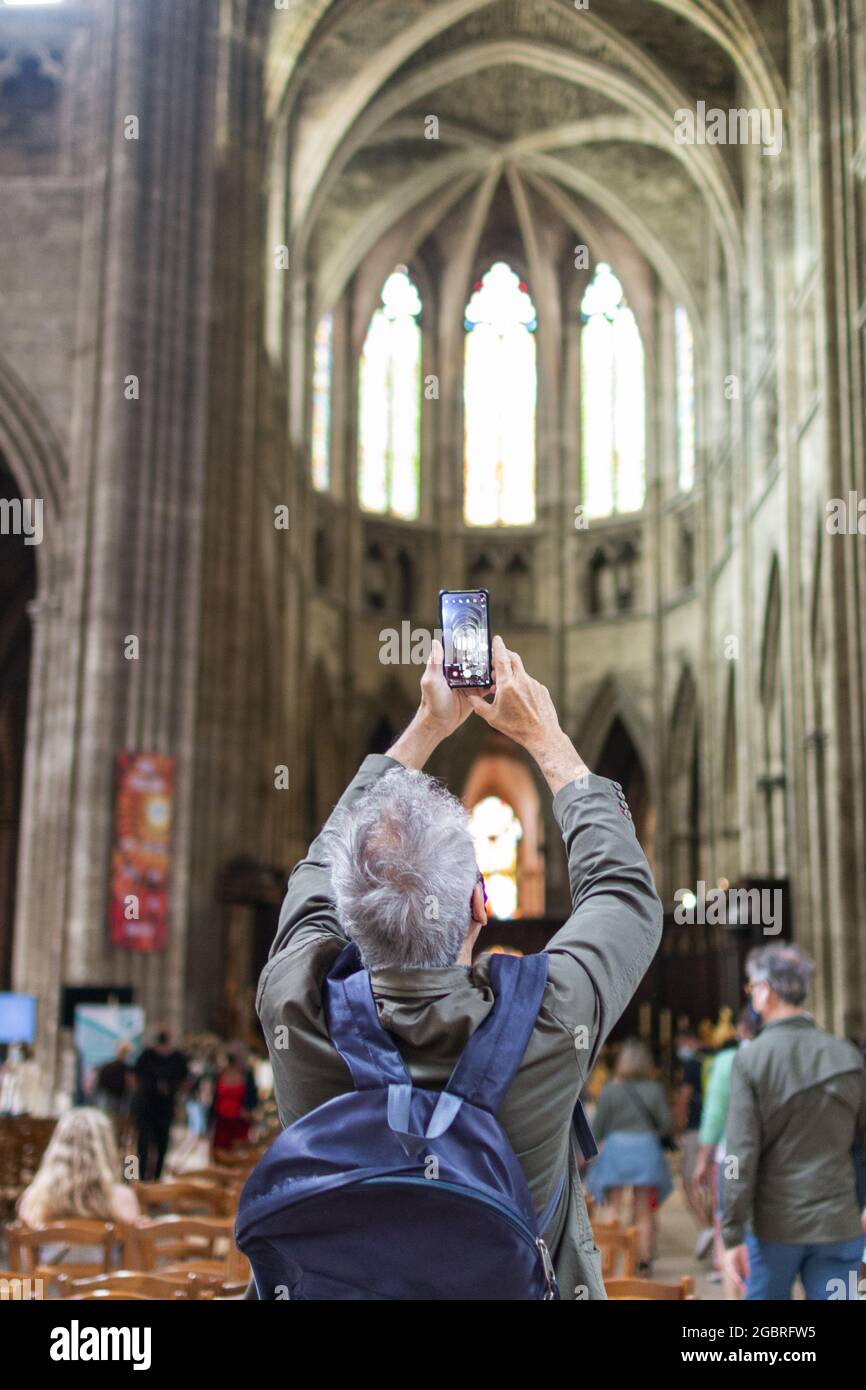 Vertical shot of a tourist taking photos inside the Bordeaux Cathedral ...