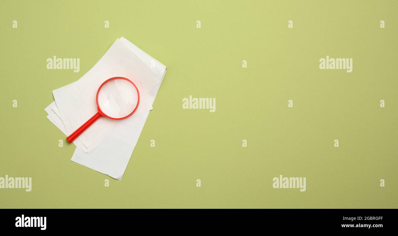 stack of paper sales receipts and red plastic magnifying glass on a ...