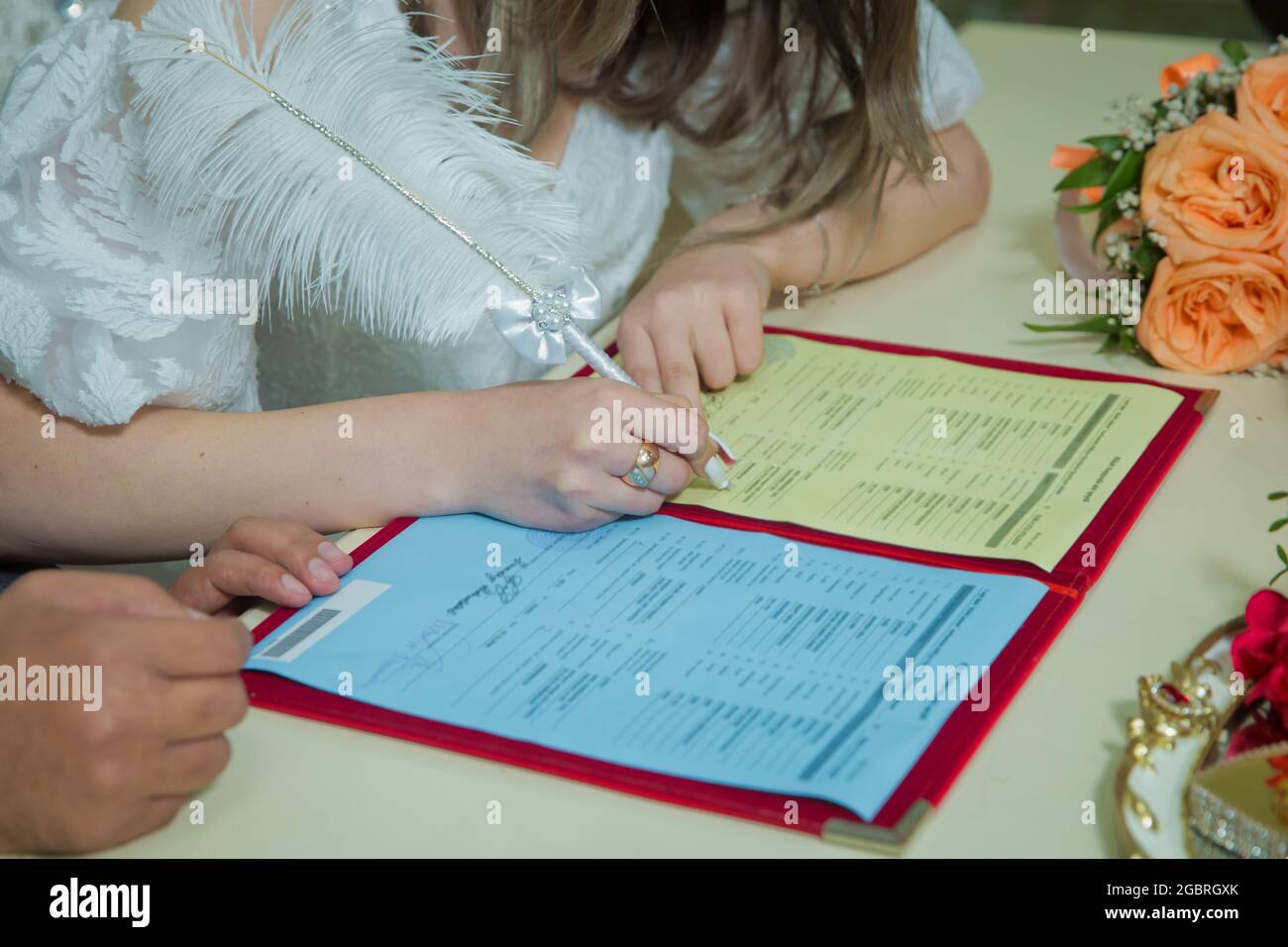 A woman's hand signs and registers his marriage with the woman he loves ...