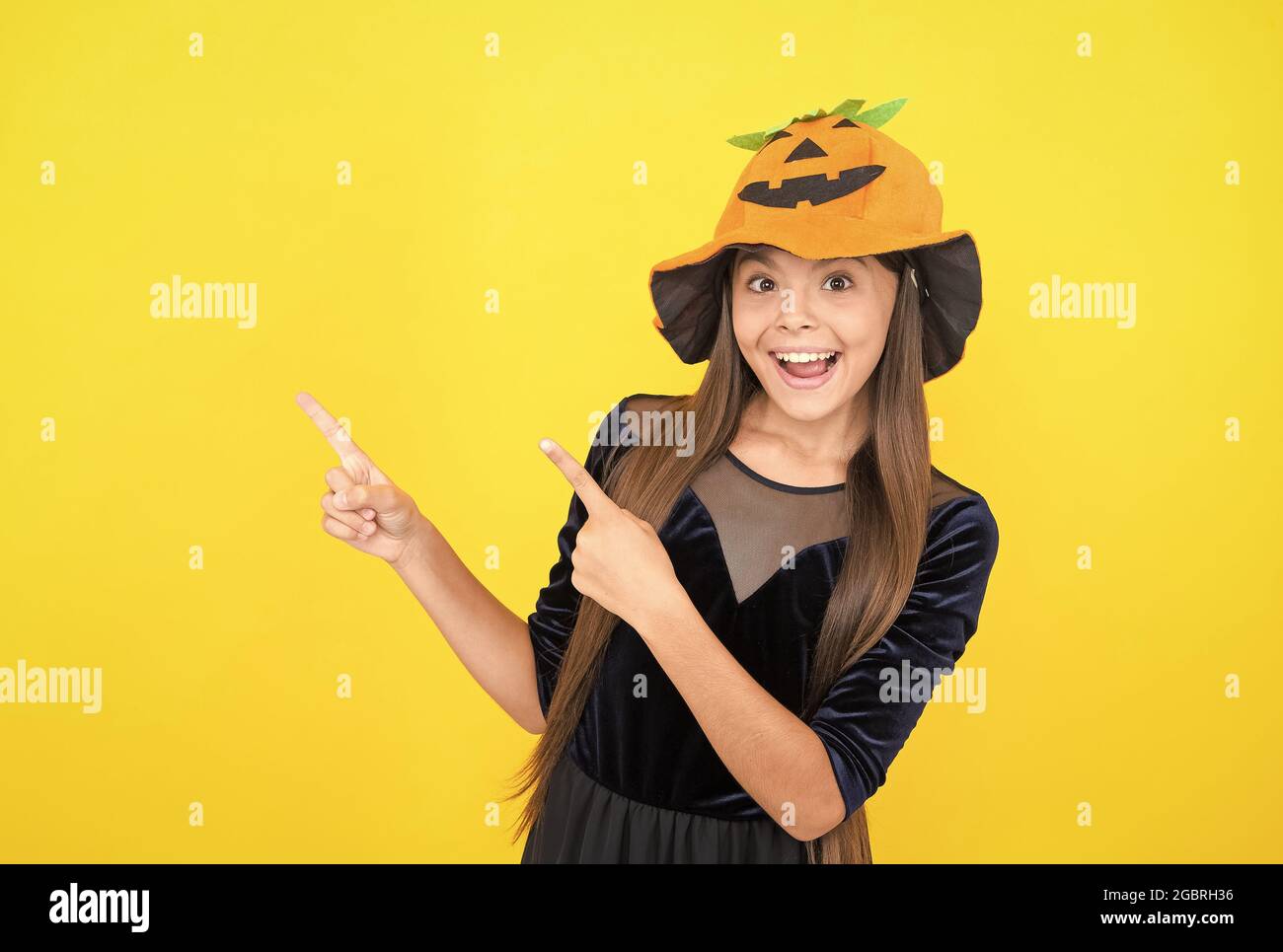 child in gourd hat pointing finger on copy space. kid wearing squash ...