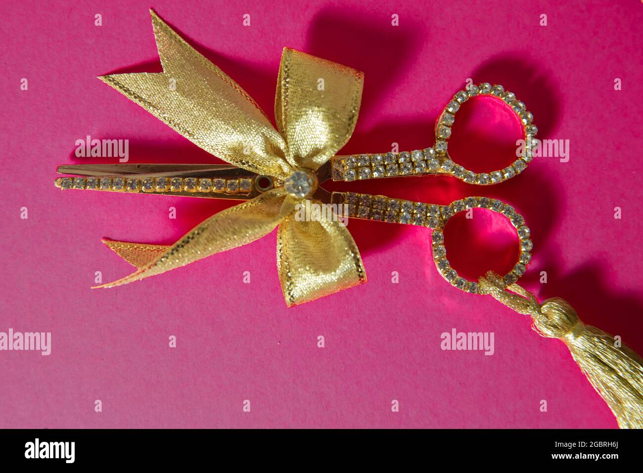 Pink ribbon on gold scissors Pink background . gold scissors pink flat ...
