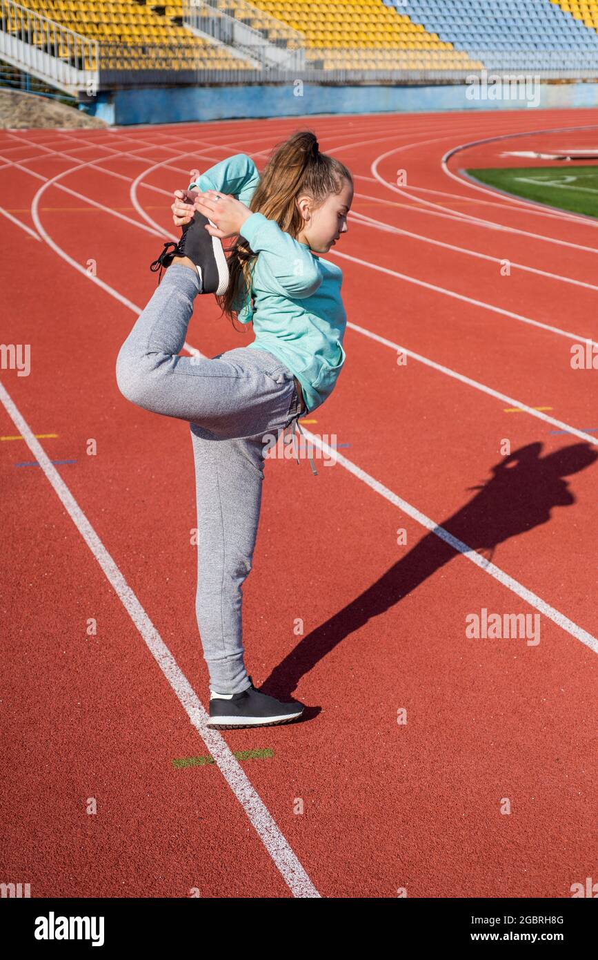 Stretching for better flexibility. Flexible child hold foot standing on leg. Flexibility ...