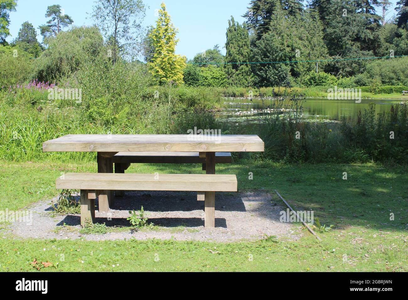 Beautiful view with a seat and a table in a green park Stock Photo - Alamy