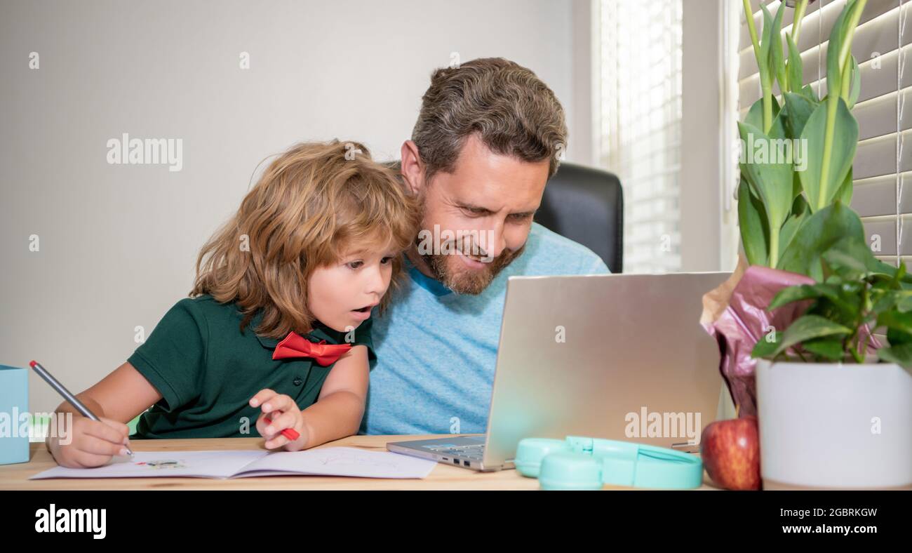 happy attentive father and child son at school working online on laptop ...