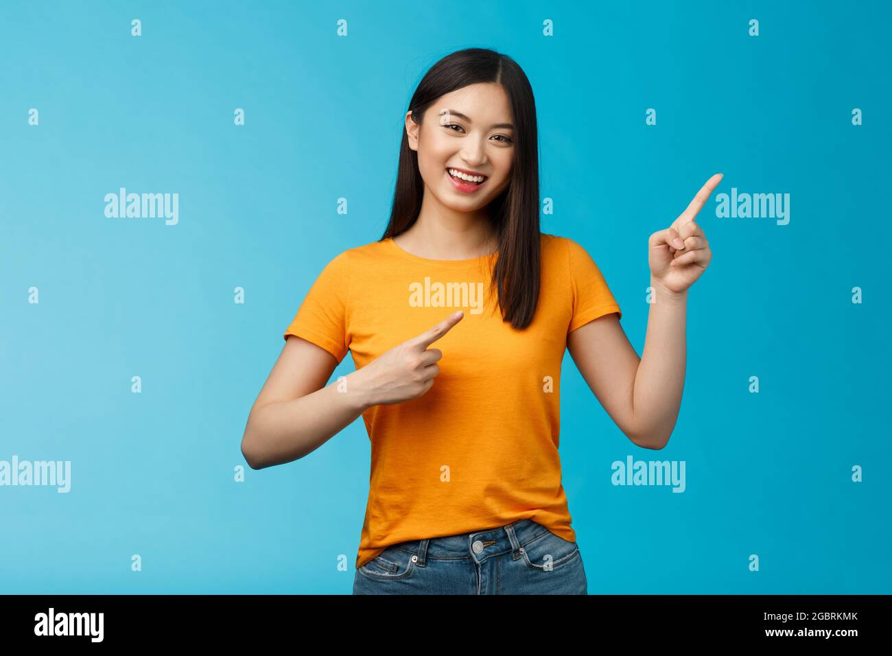 Cheerful lively cute asian woman smiling laughing upbeat, pointing ...