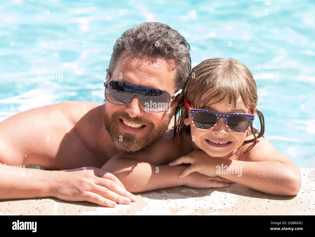 father and son wear glasses in swimming pool water. daddy with kid boy ...