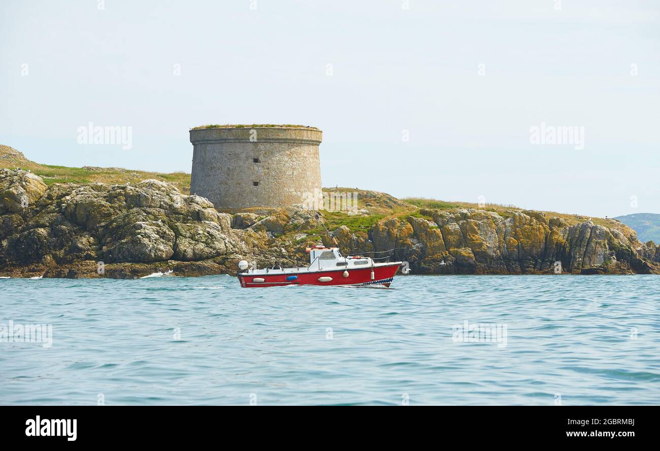 Red fishing boat in the sea with Lambay Island in background ...