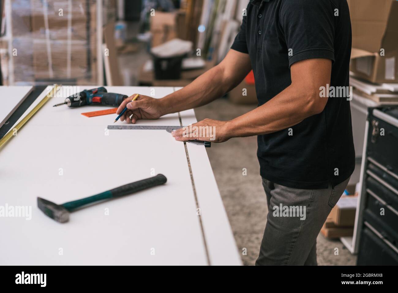 Man measuring a surface with a square in a workshop Stock Photo - Alamy