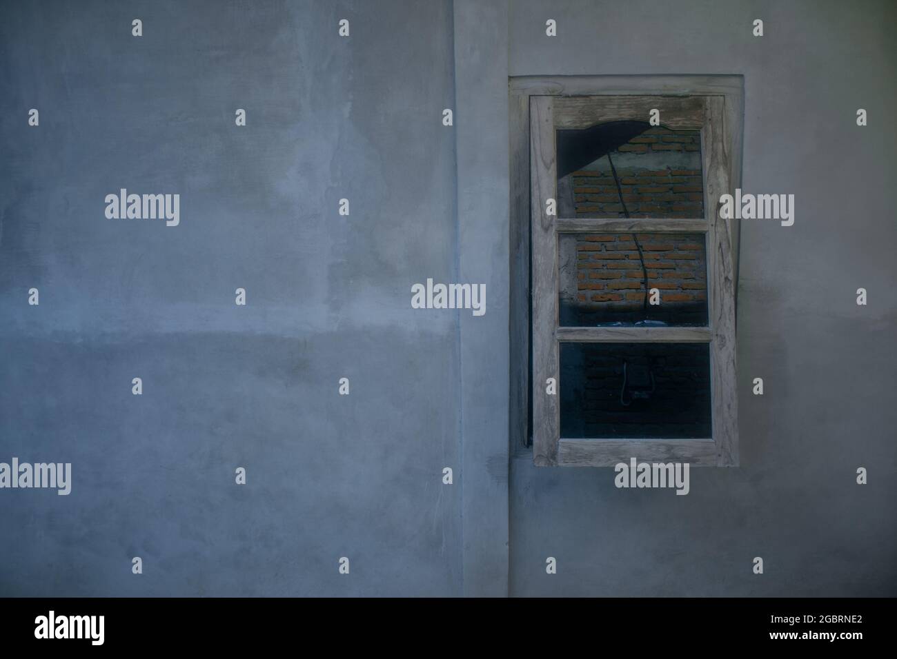 Half open wooden window on ultimate grey plastered wall background ...