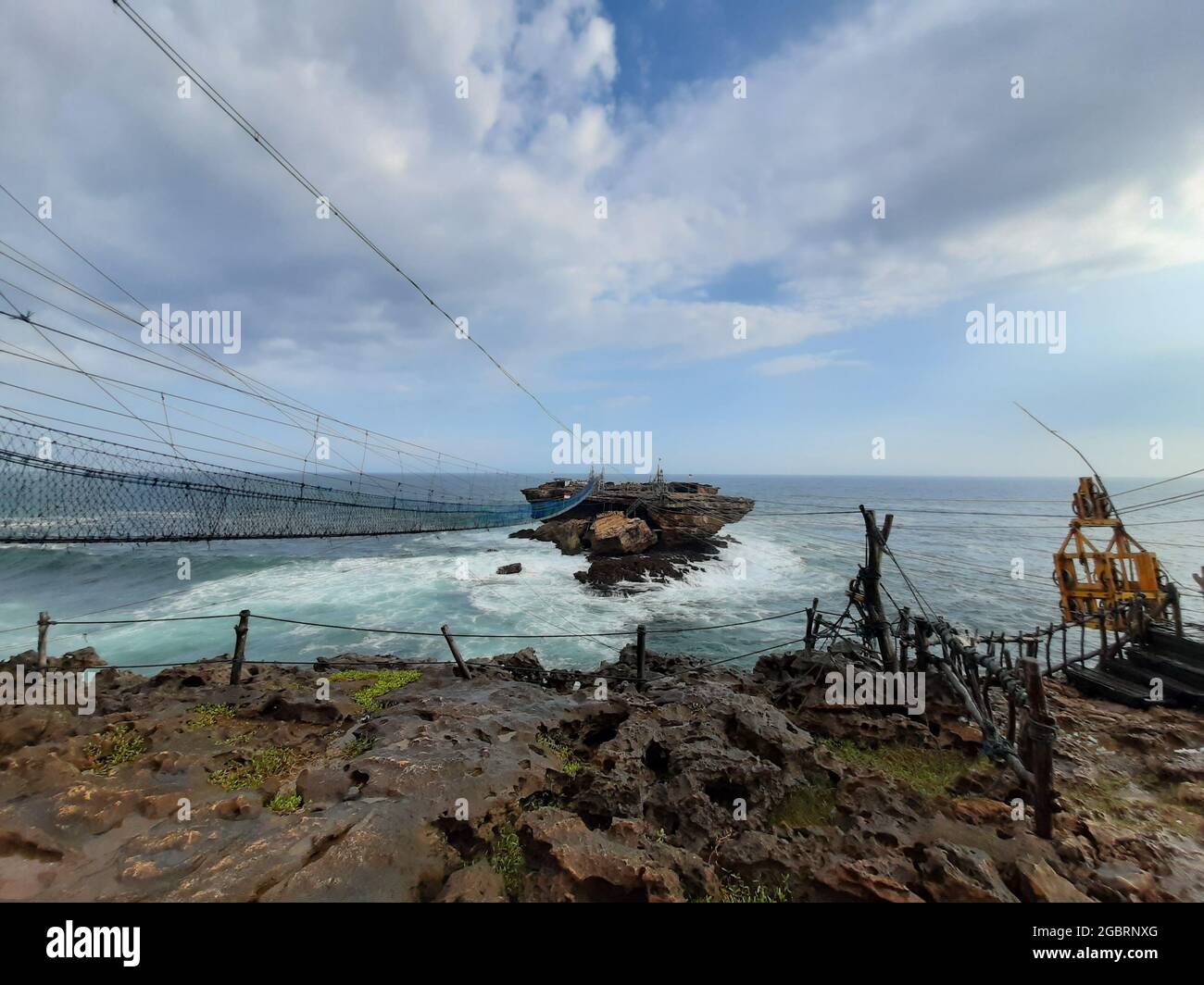 A rock plateau and a rock island in the sea connected with a rope foot ...