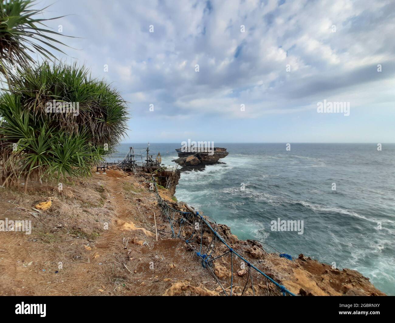 A rock plateau and a rock island in the sea connected with a rope foot ...