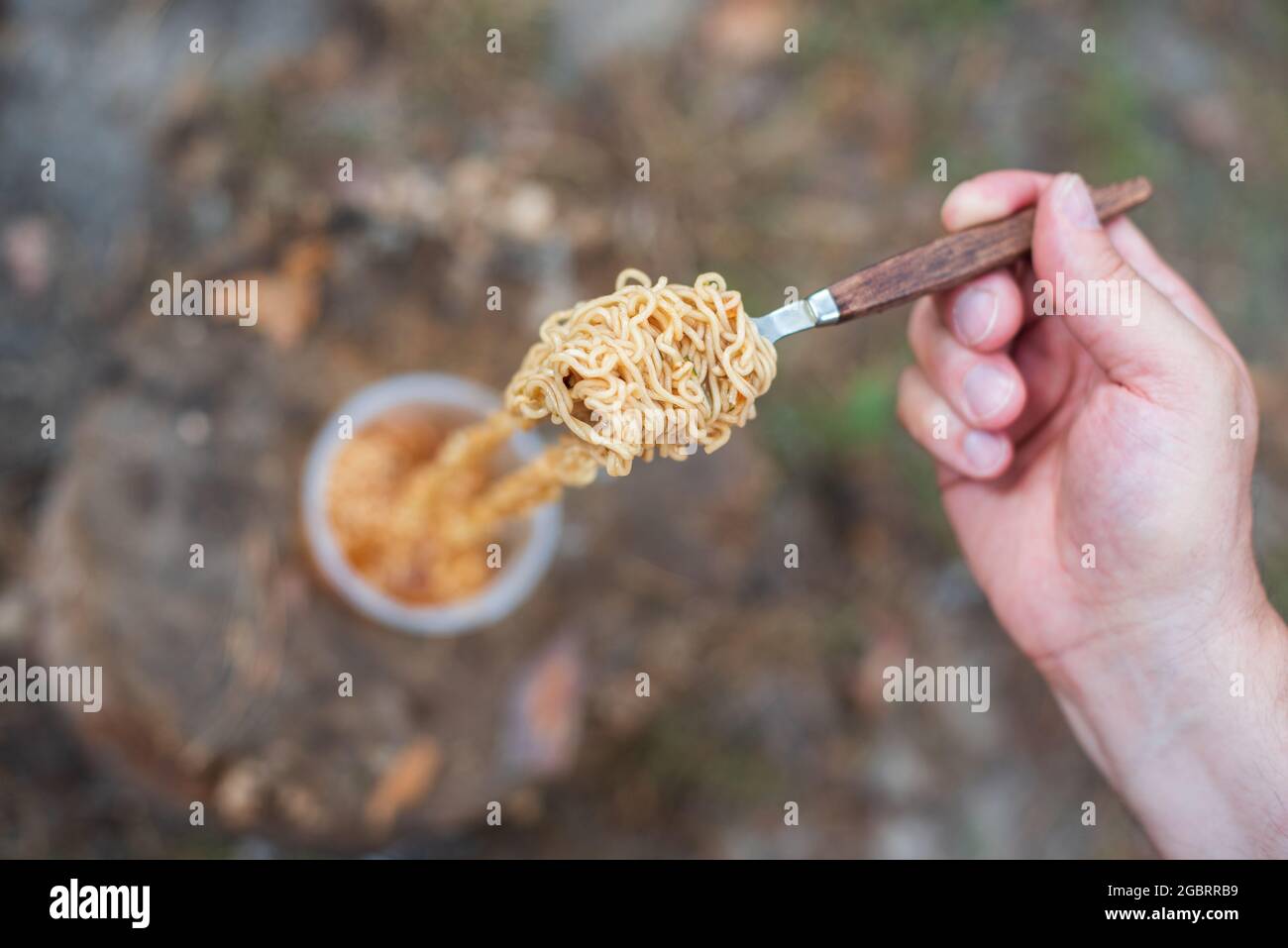 Eating Instant noodles in a plastic bowl in nature background. Eating ...