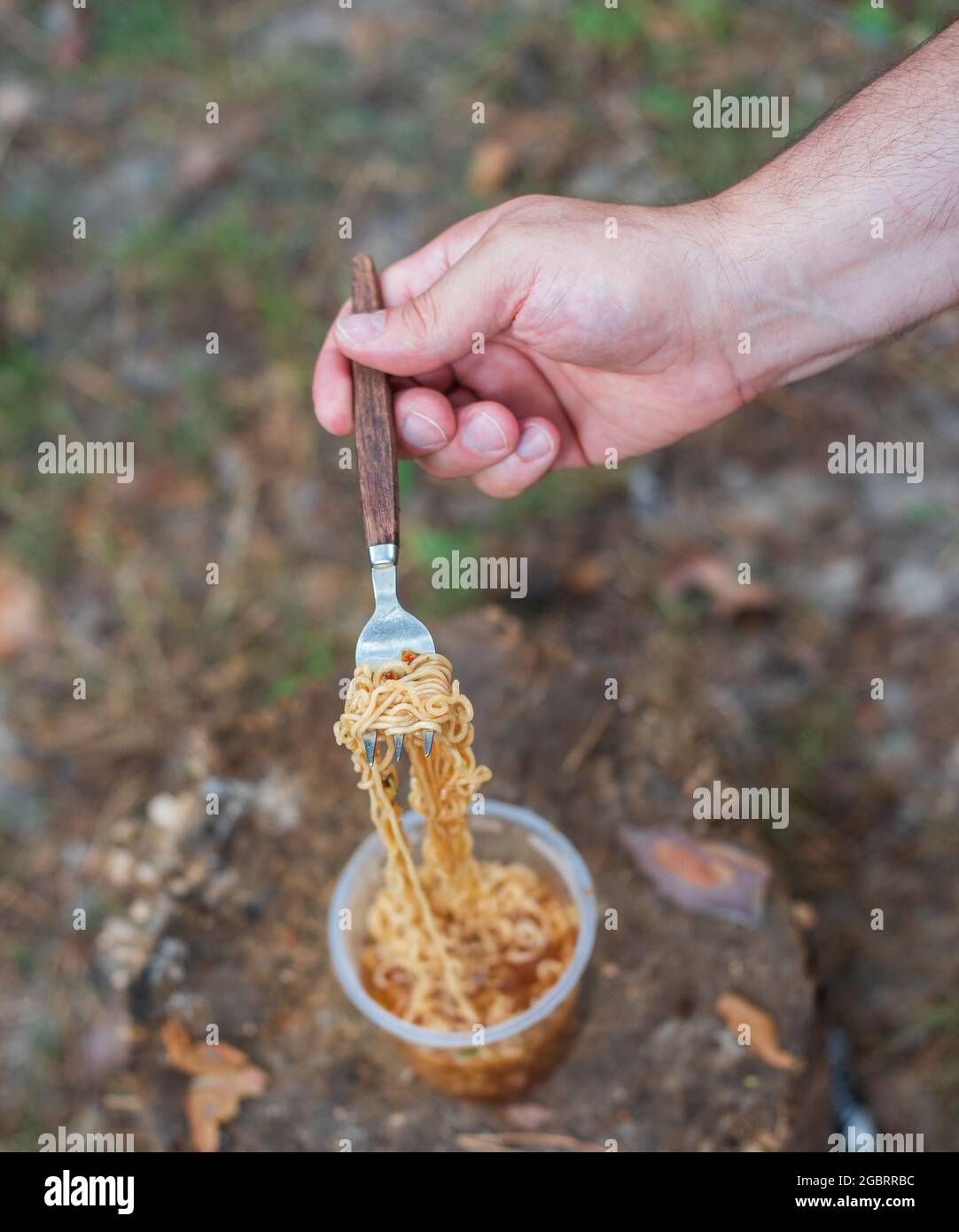 Eating Instant noodles in a plastic bowl in nature background. Eating ...
