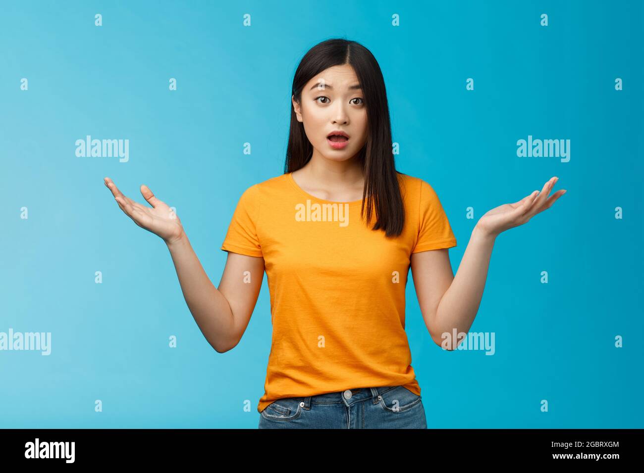 Questioned unaware young asian girl with dark short haircut shrugging ...