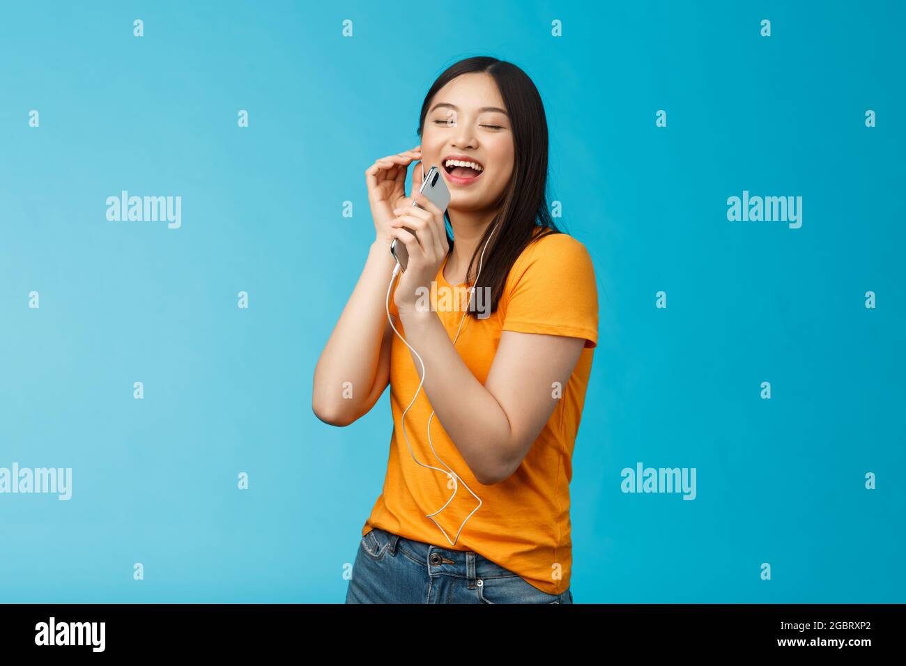 Joyful carefree attractive asian woman close eyes pleasure and joy ...