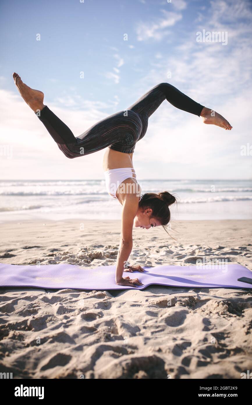 Young woman doing handstand on beach hi-res stock photography and ...