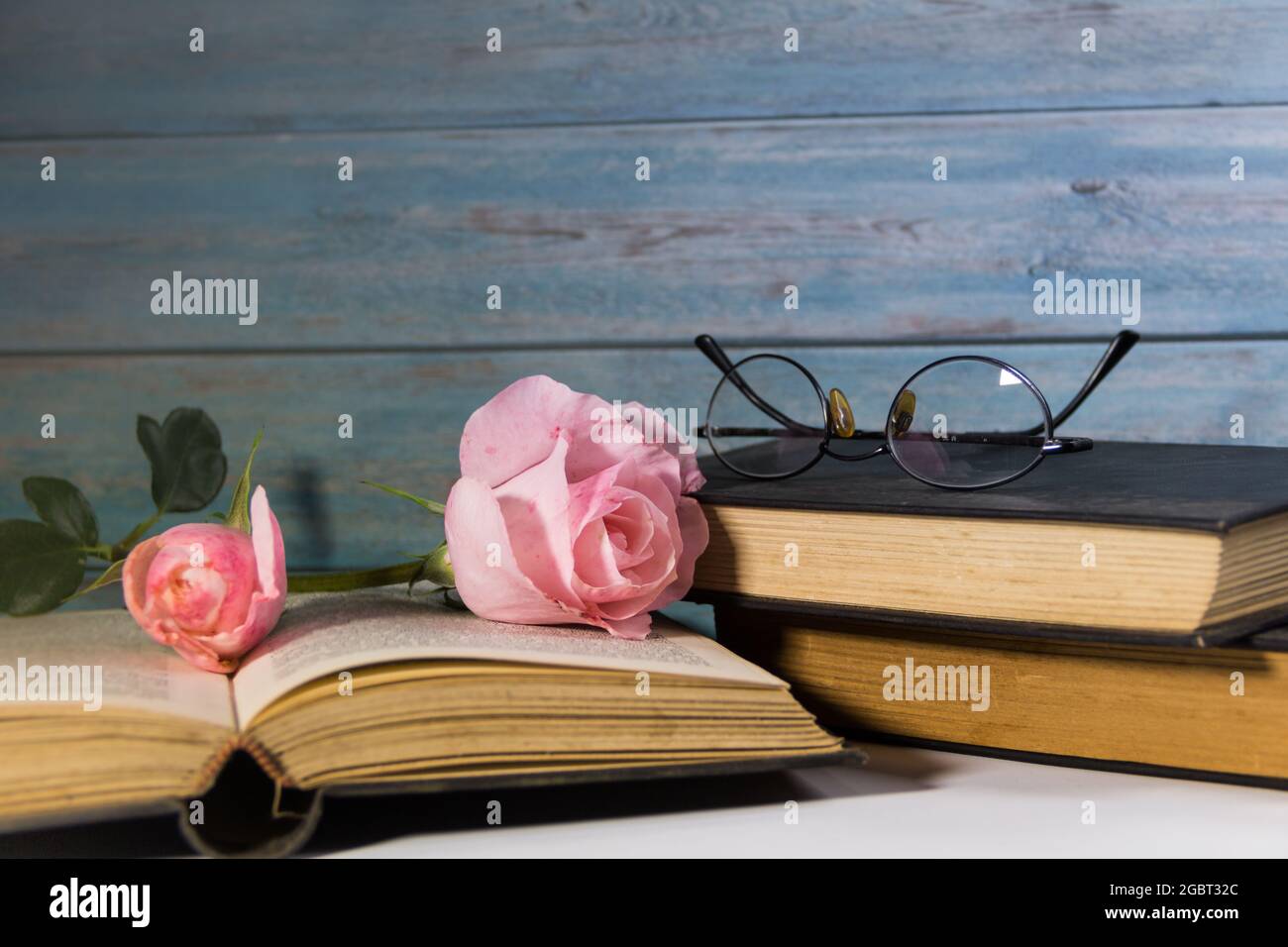 pink roses and books on rustic wood Stock Photo - Alamy