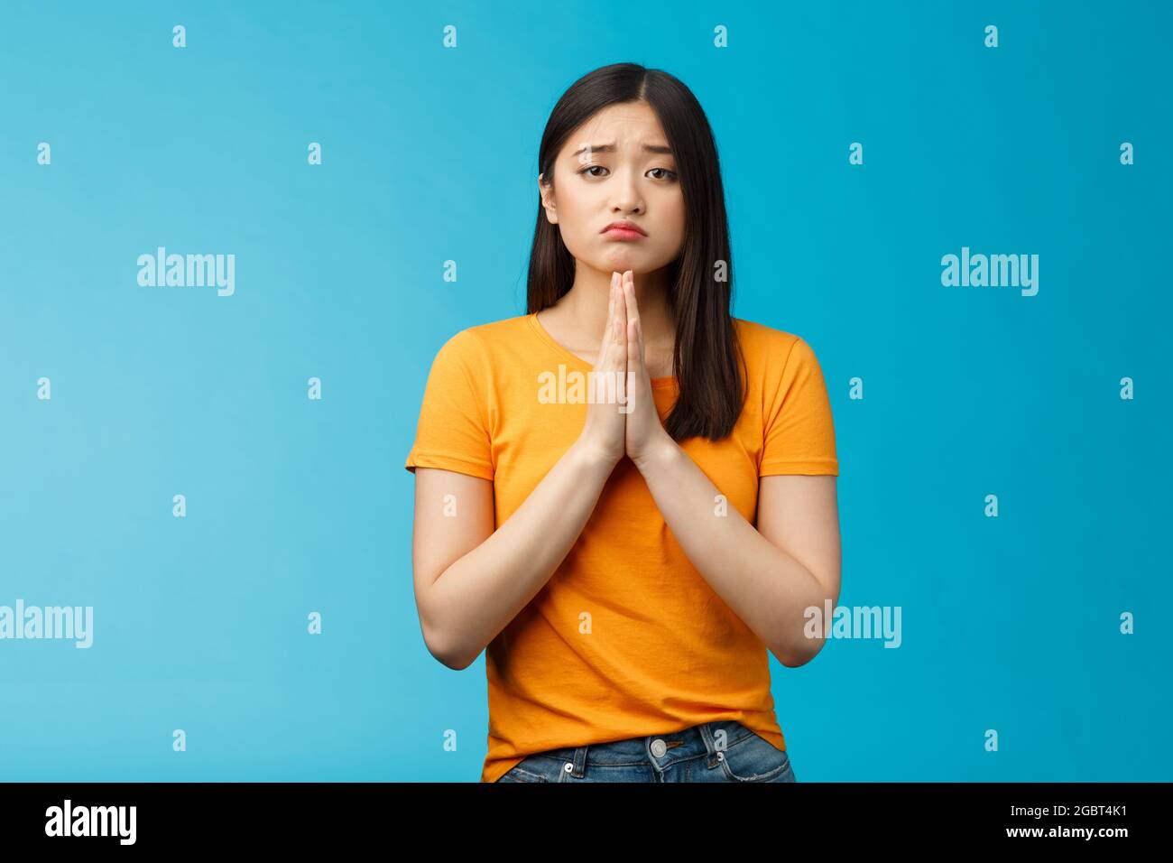 Upset cute silly asian girl praying, plead for help, pouting frowning ...