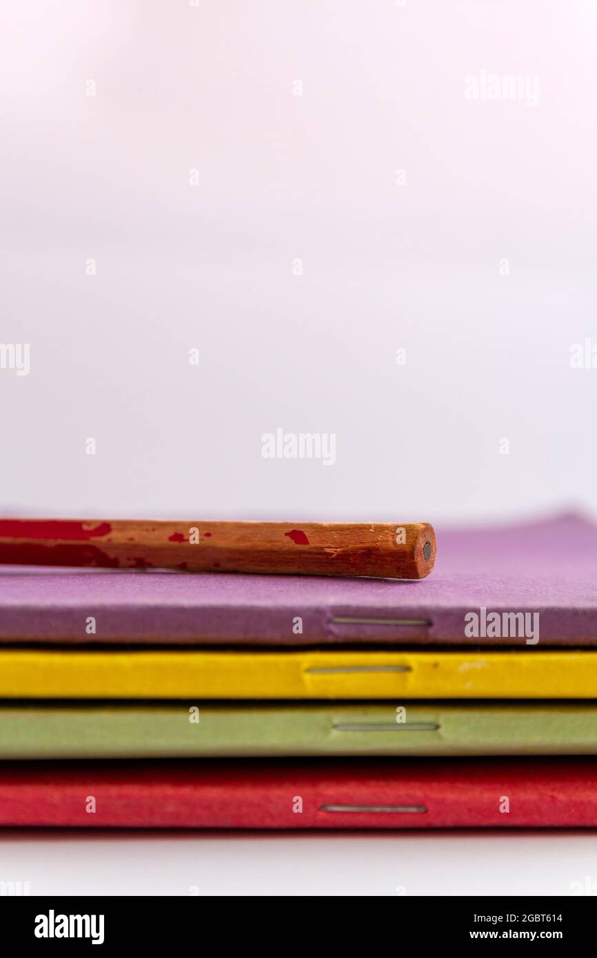 Front on view of a chewed pencil end on top of a pile of coloured ...