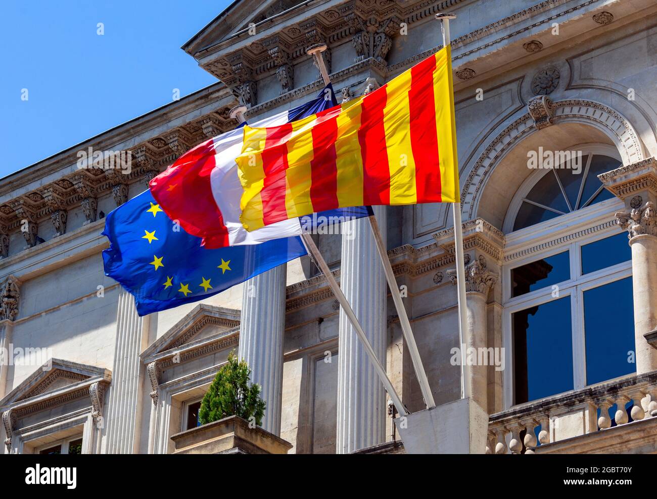 Multi-colored waving national flags on the facade of the city hall ...