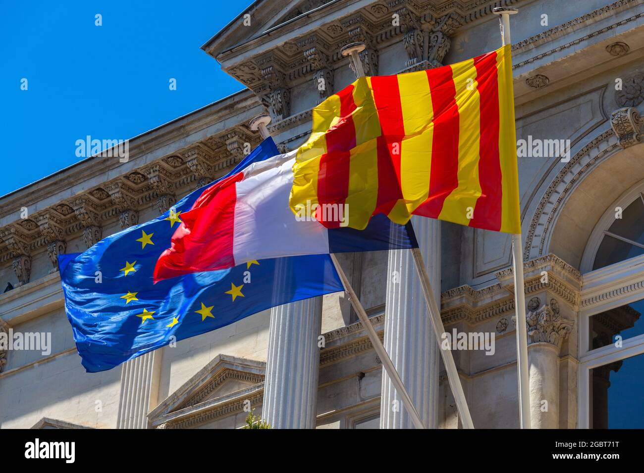 Multi-colored waving national flags on the facade of the city hall ...